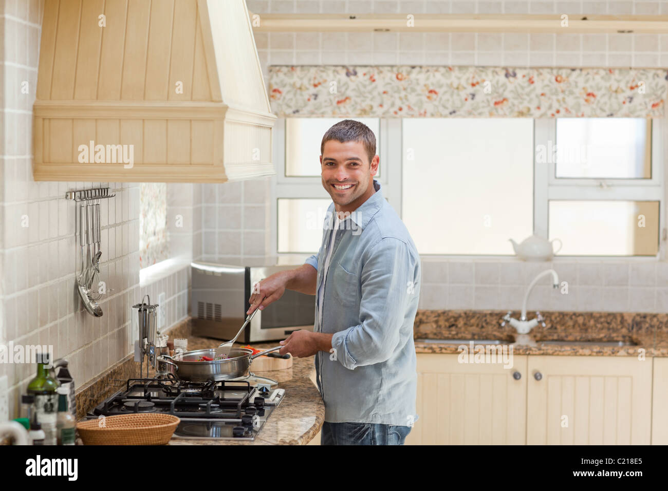 Handsome man cooking in the kitchen Stock Photo - Alamy