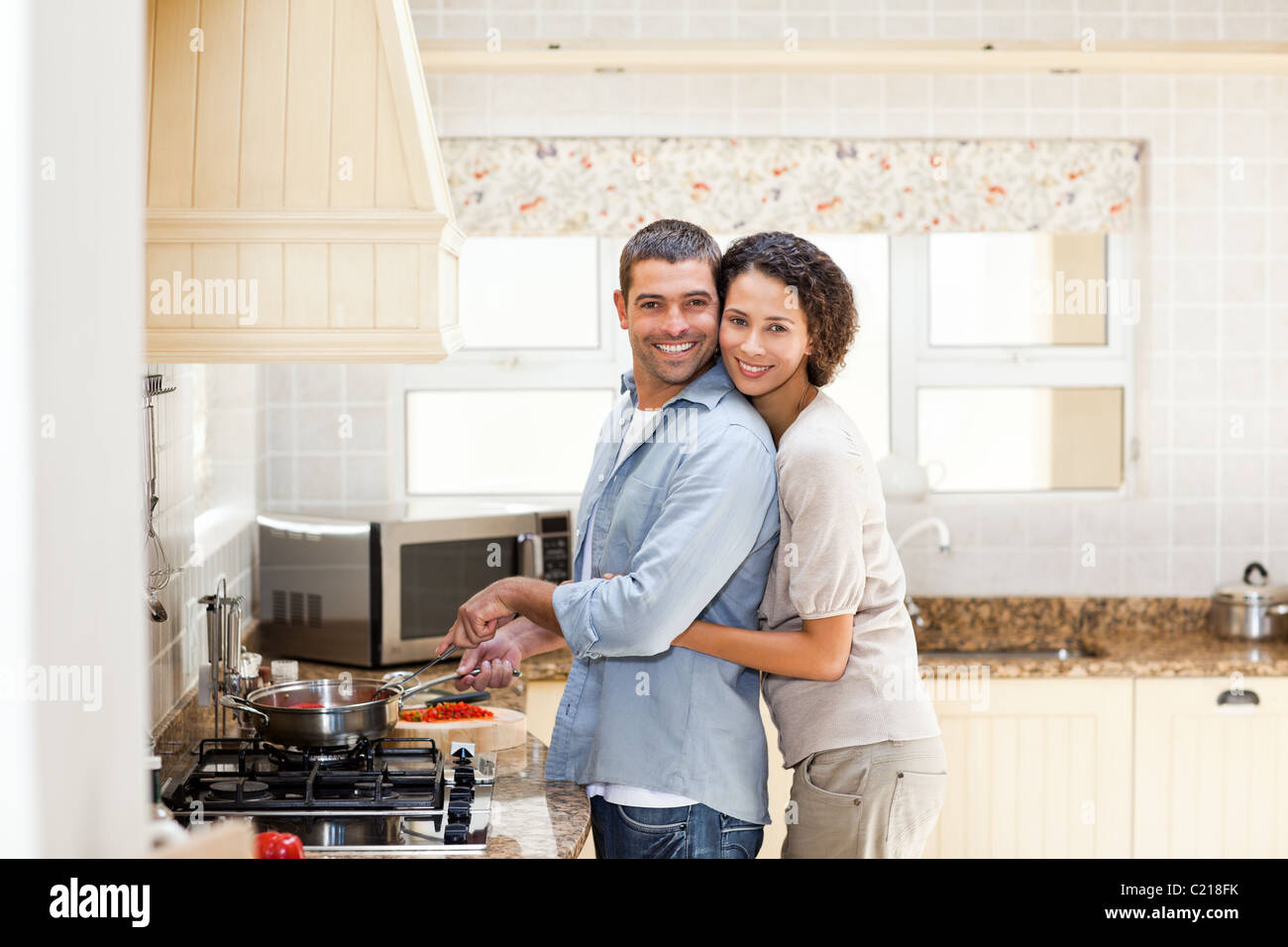 Woman hugging her husband while he is cooking Stock Photo - Alamy