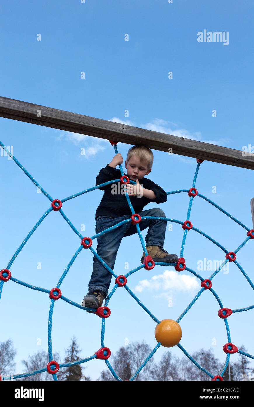 A child blond boy 4 years on a playground, rope net, spring park Stock ...