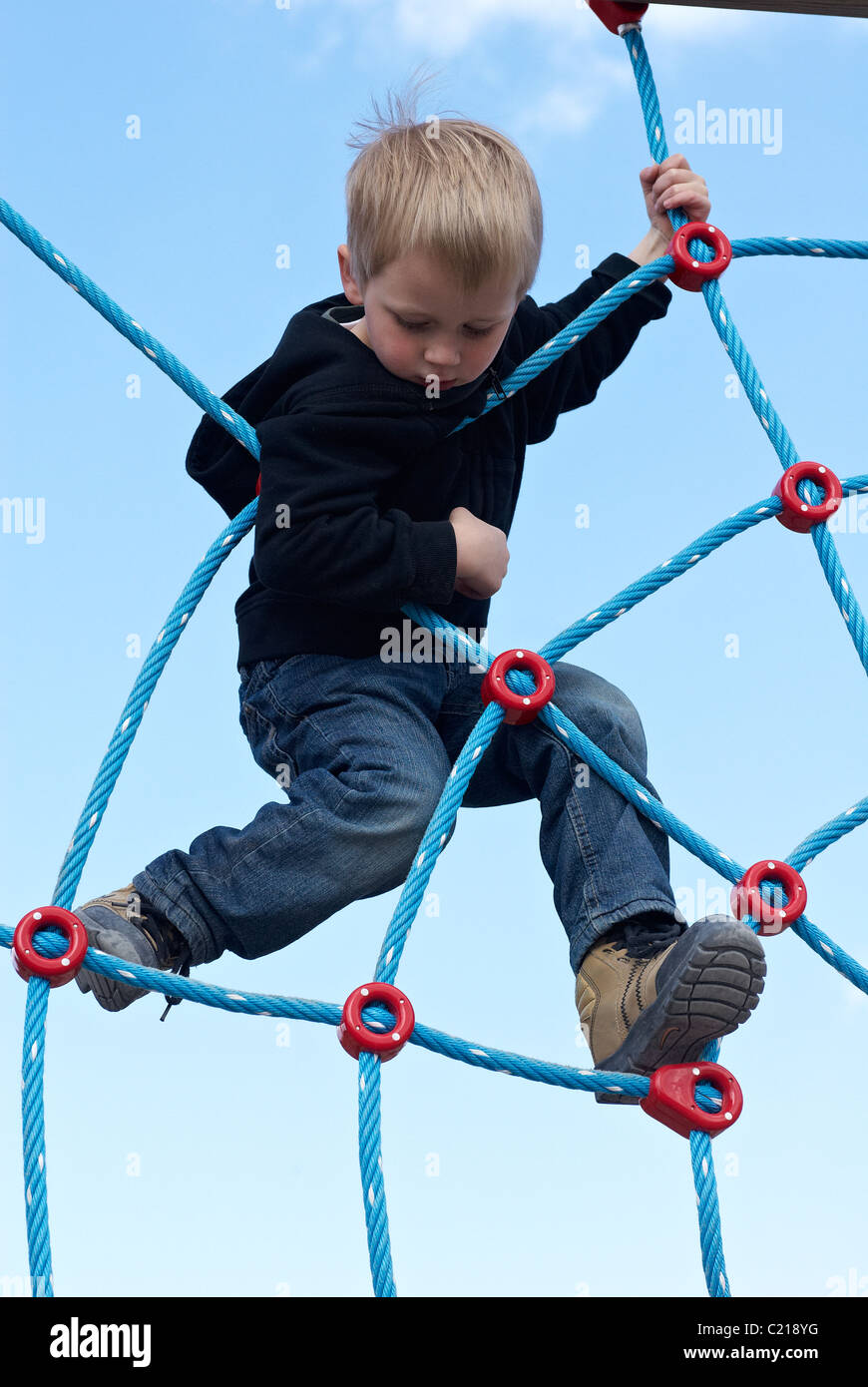 A child blond boy 4 years on a playground, rope net, spring park Stock ...