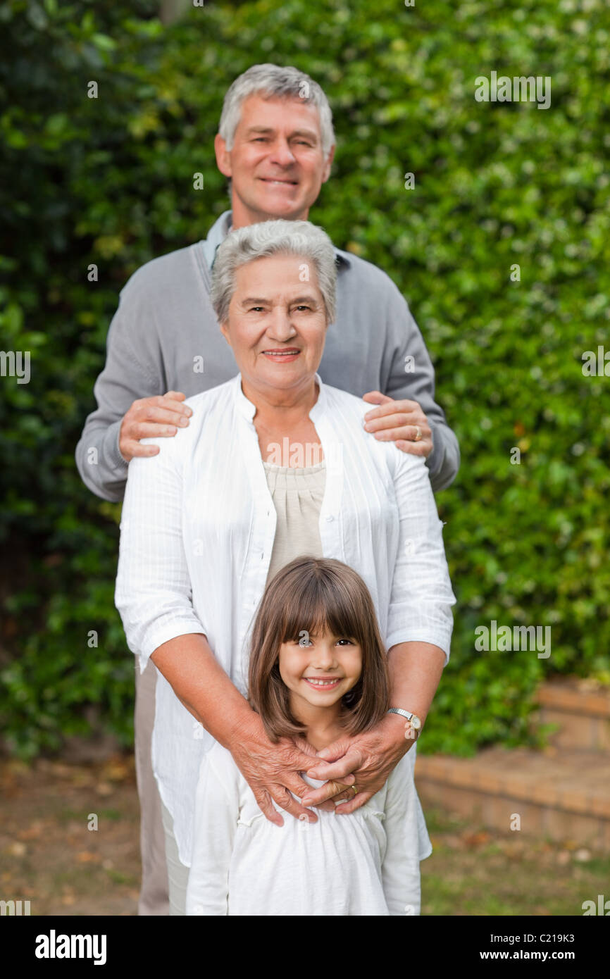 Smiling family looking at the camera in the garden Stock Photo - Alamy