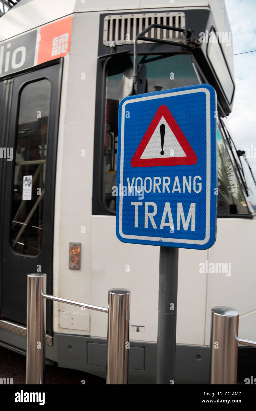 A tram passing a sign warning pedestrians to give priority (voorrang ...