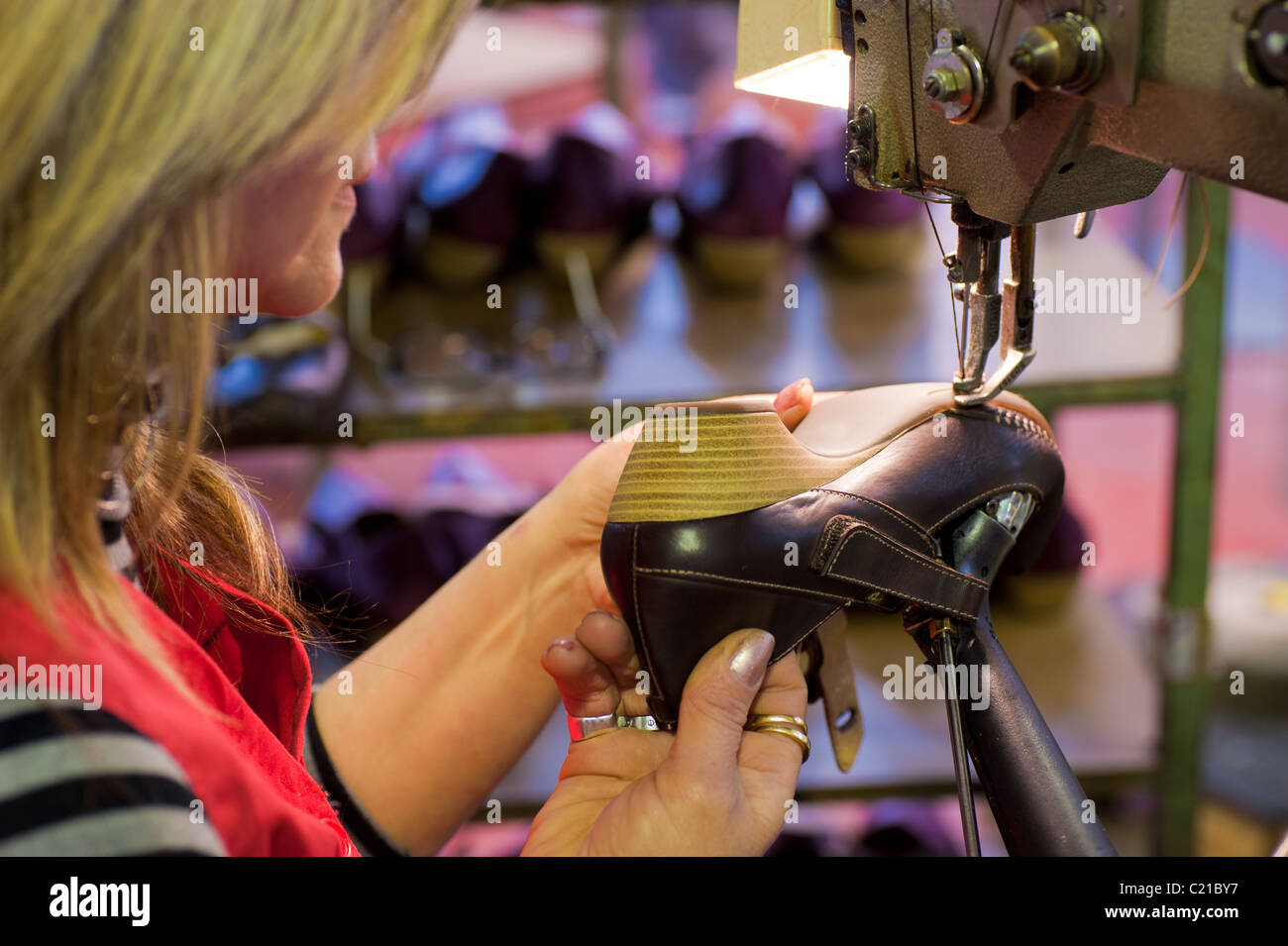 Experienced worker sewing leather shoes in a production line Stock ...