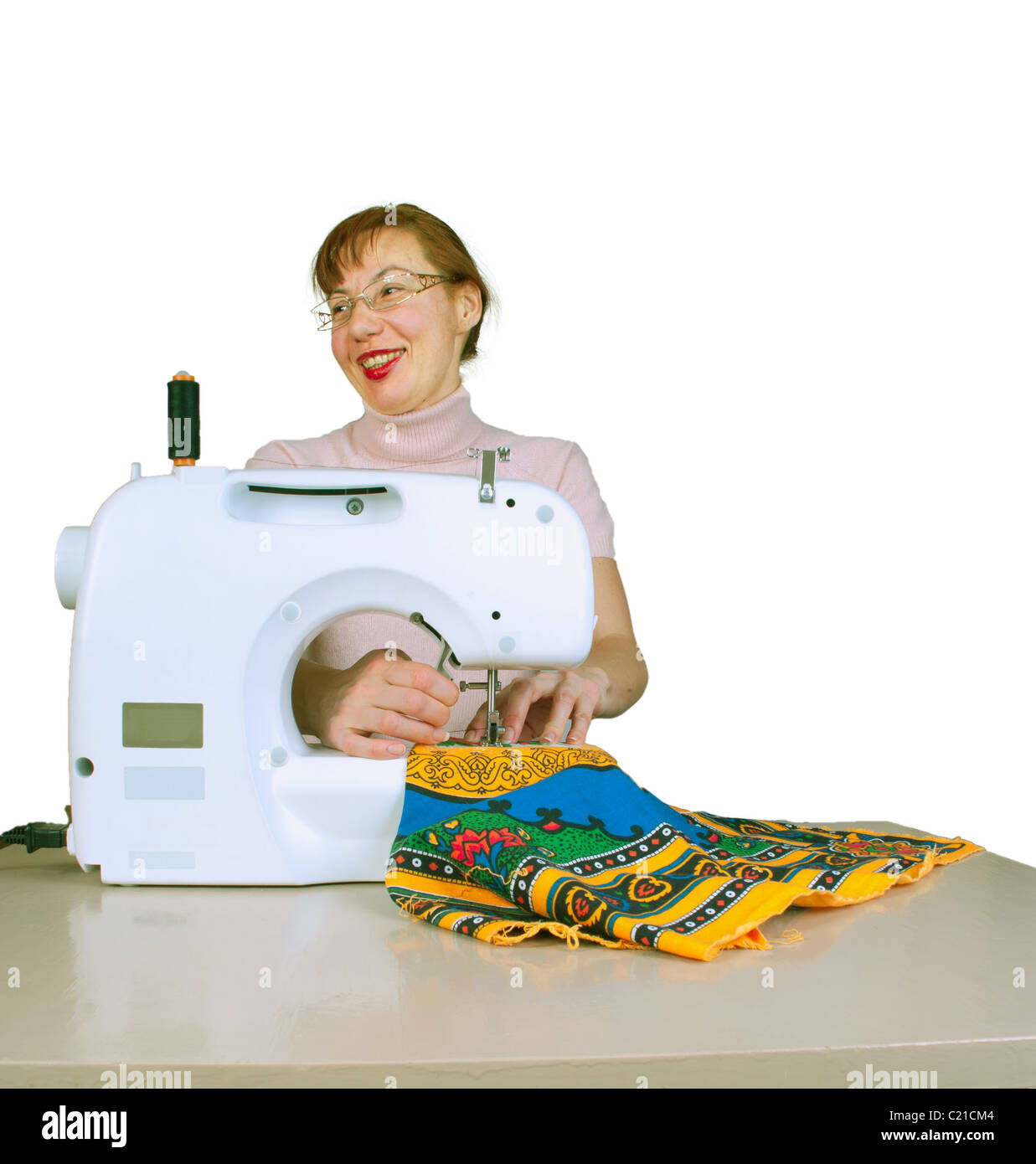 Smiling woman sewing at home in the kitchen with her friend Stock Photo ...