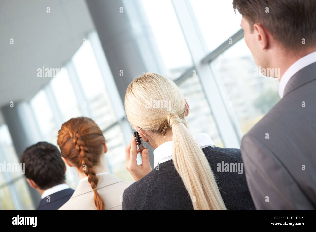 Rear view of business woman calling among her colleagues Stock Photo ...