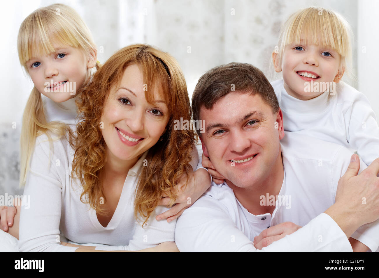 Portrait of cheerful family in white clothes looking at camera Stock ...