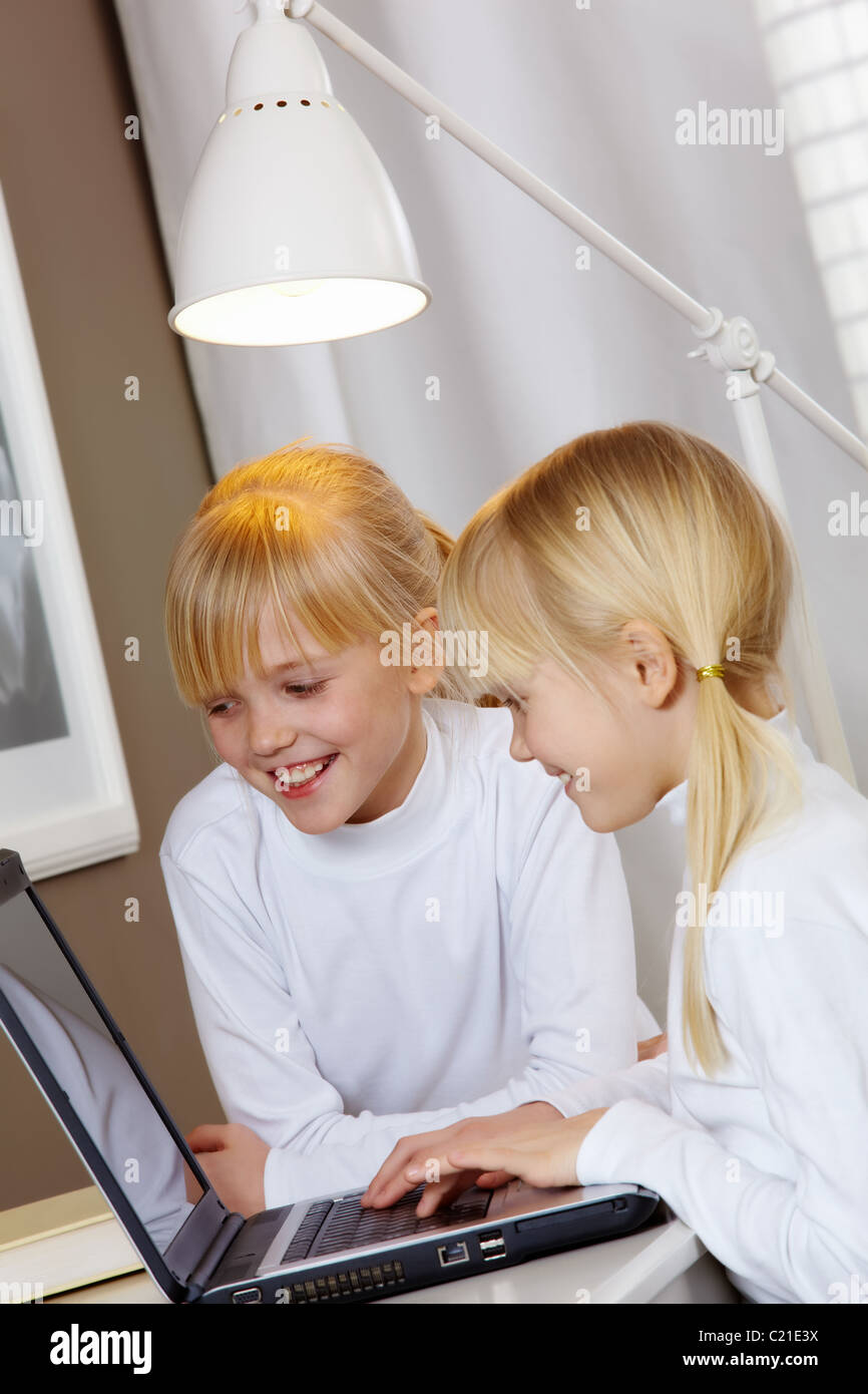 Portrait of two girls doing homework at computer Stock Photo - Alamy