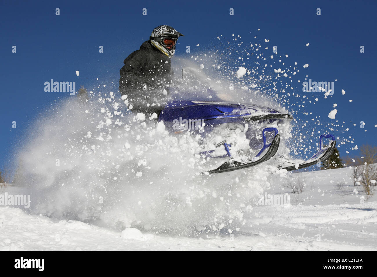 snowmobile rider jumping through snow Stock Photo - Alamy