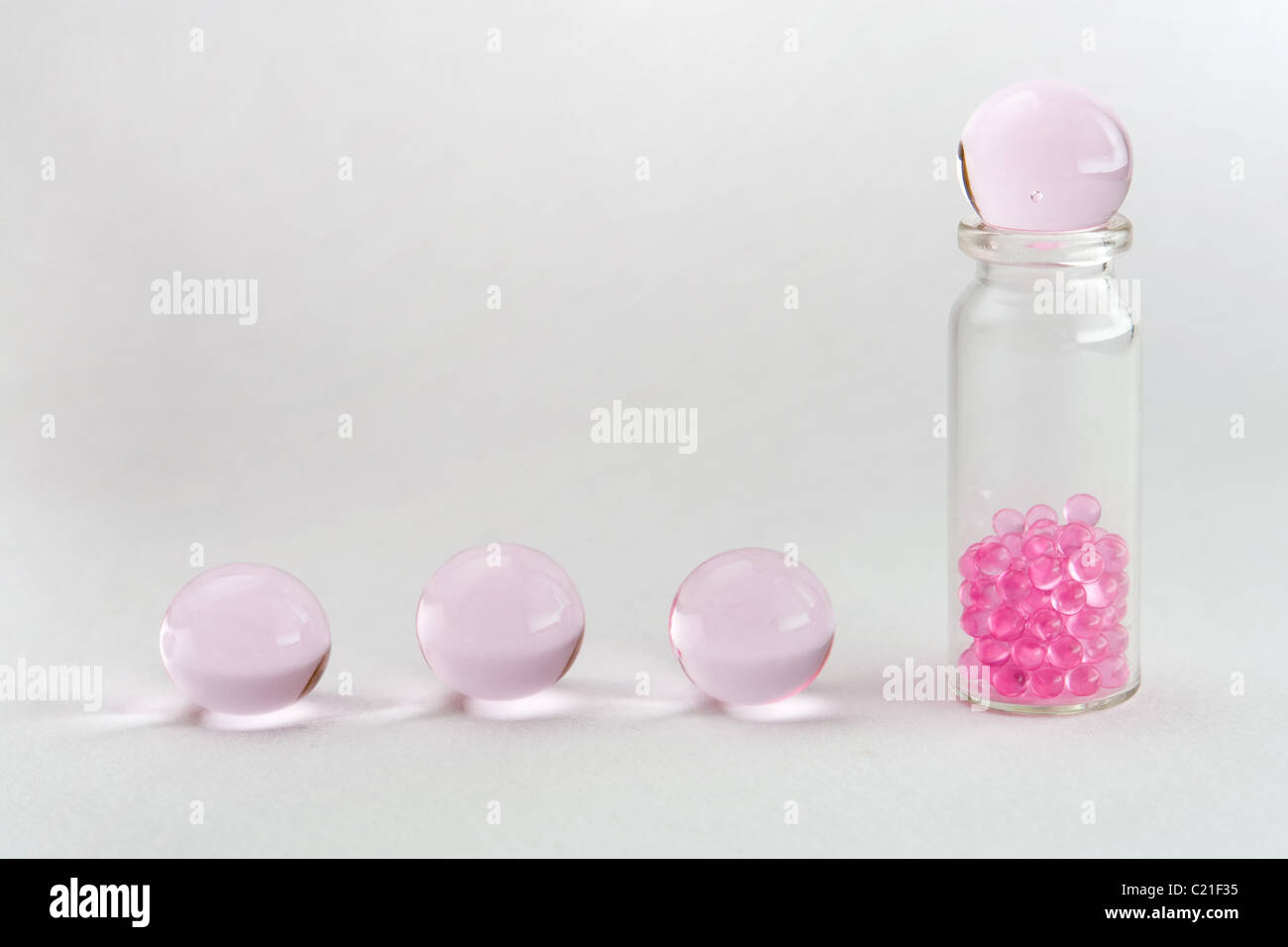 Pink Gel balls and small jar of tiny balls Stock Photo - Alamy