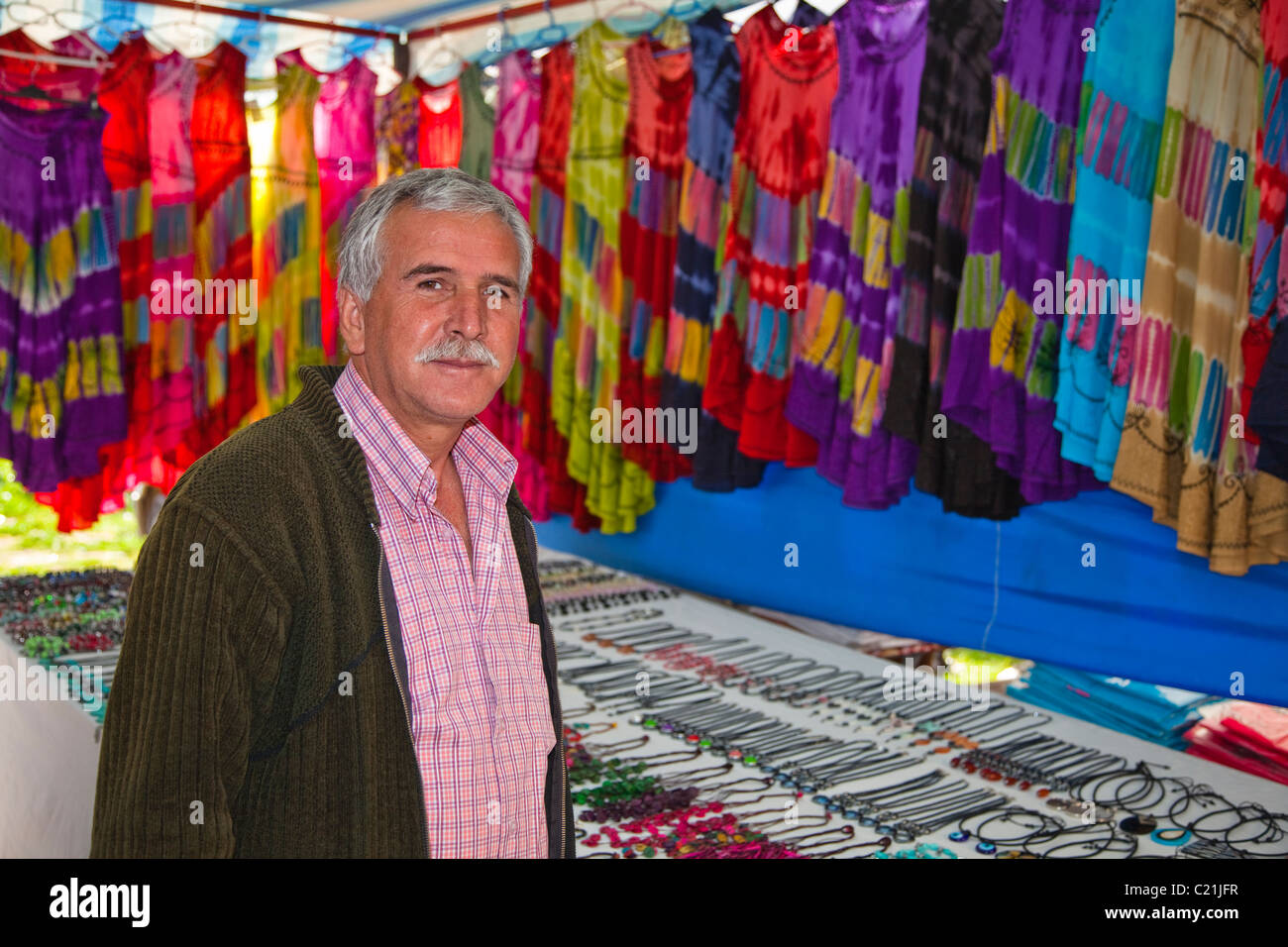 Turkish man selling clothing and fabrics at a bazaar in Belek, Antalya ...