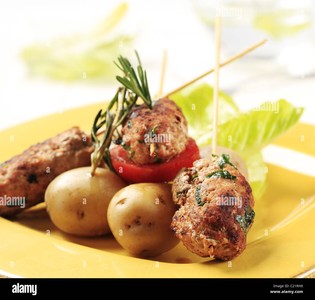 Minced meat kebabs on sticks and new potatoes Stock Photo - Alamy