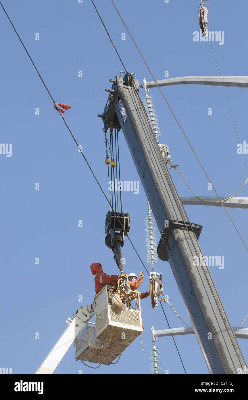 Men working on high power lines and tower Stock Photo - Alamy