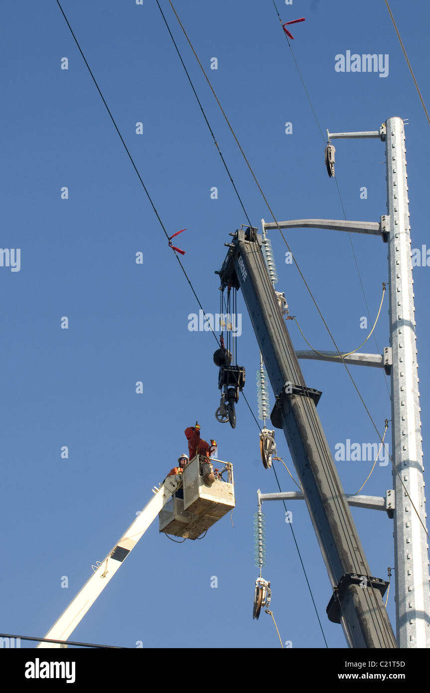 Man working on high power lines and tower Stock Photo - Alamy