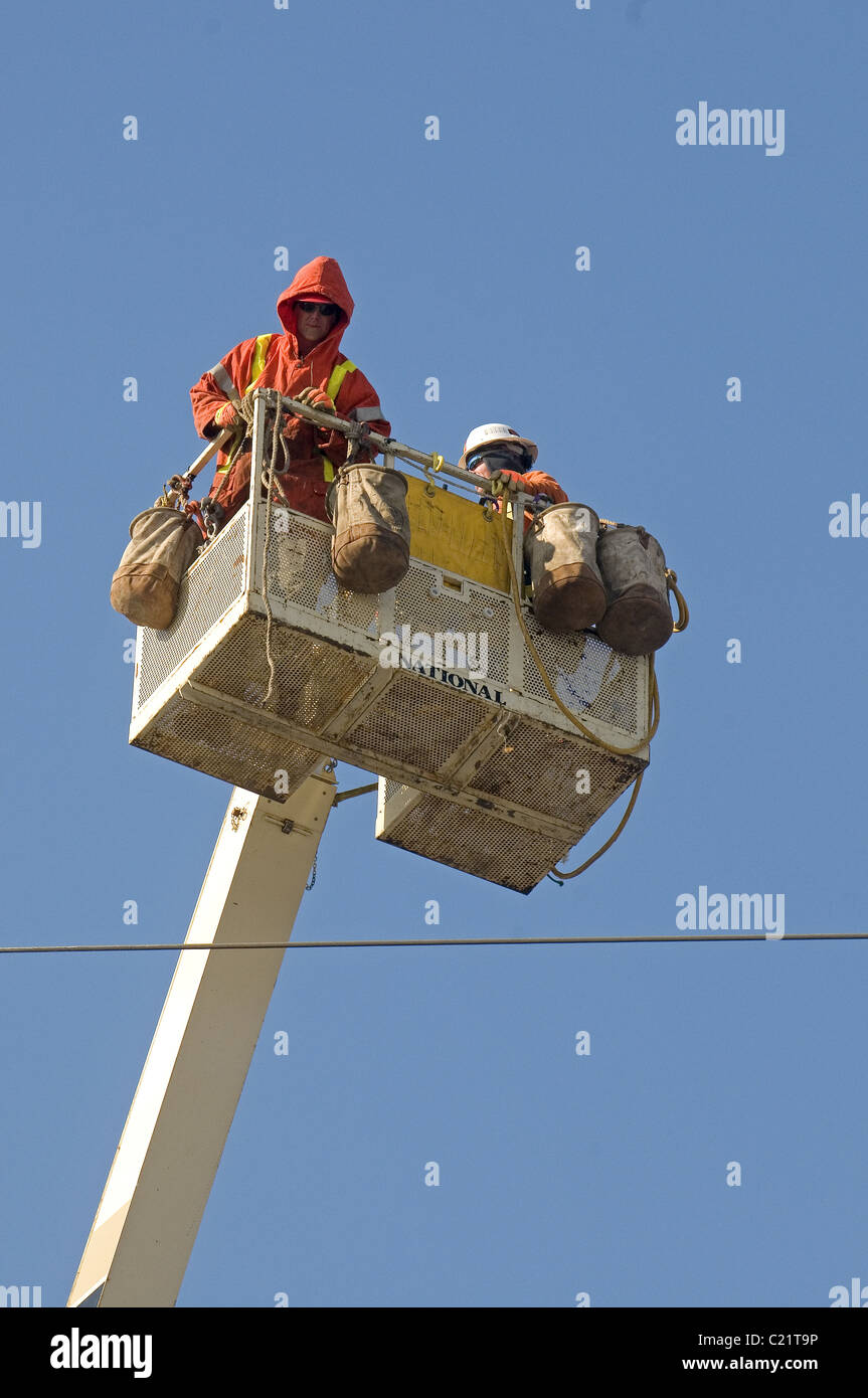 Men working on high power lines and tower Stock Photo - Alamy