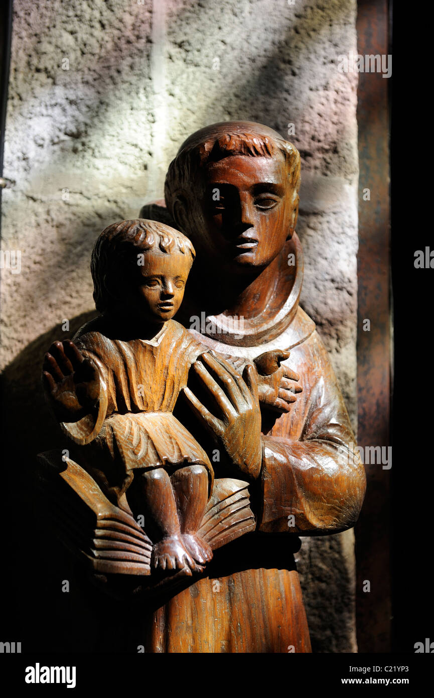 Stock photo of a wooden religious carving of a monk holding a child ...