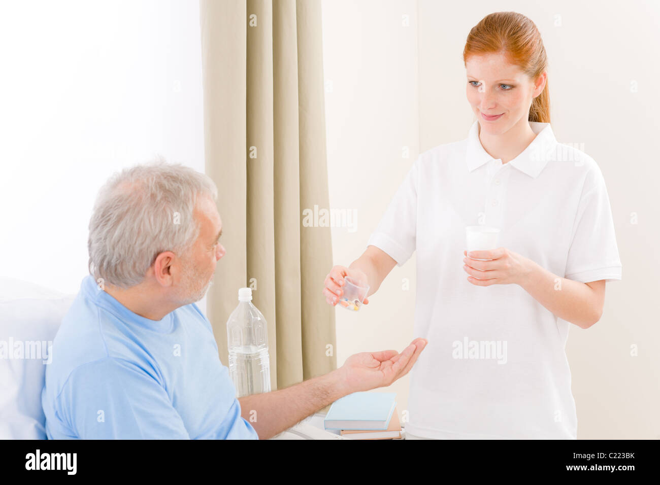 Hospital - female nurse give pill to senior patient Stock Photo - Alamy