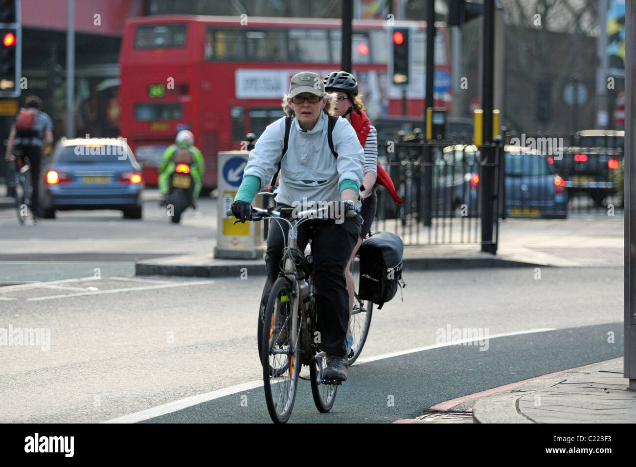 Two females cycling in a cycle lane in London, England on a cool day ...