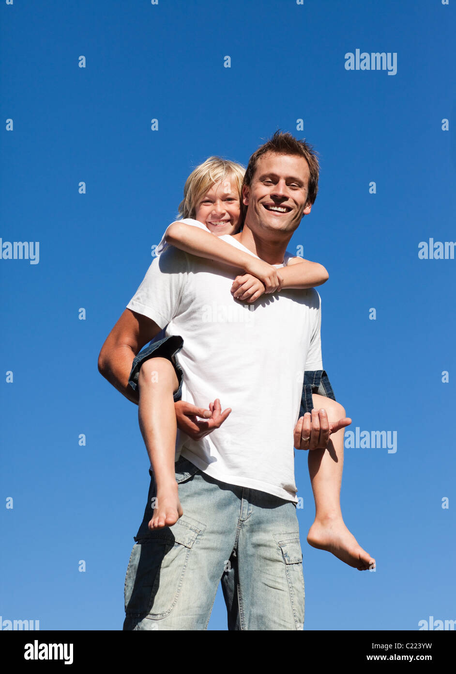 Smiling father with his son on his back outdoor Stock Photo - Alamy