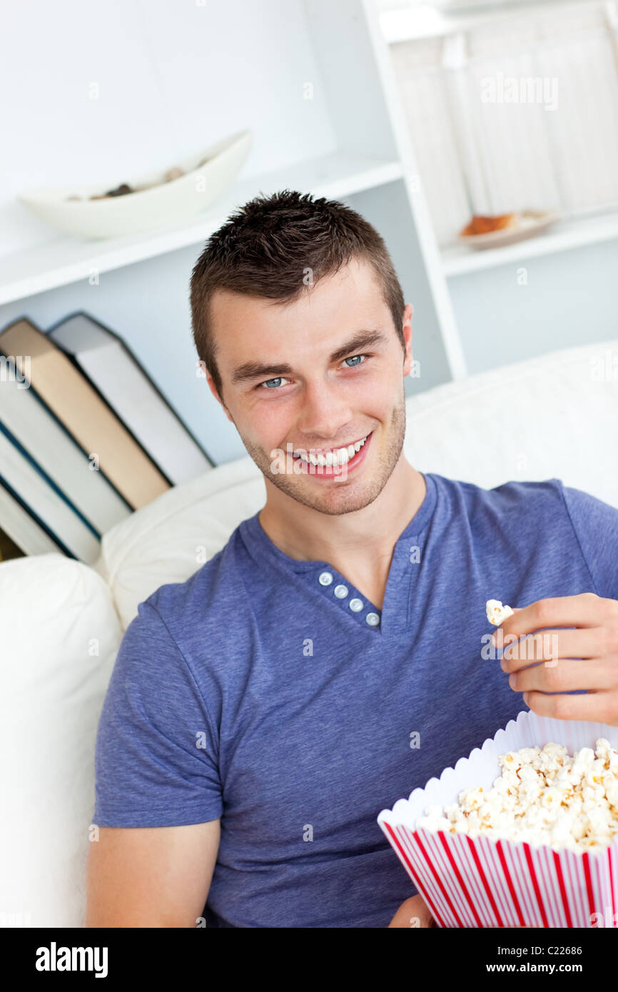 Laughing man eating popcorn looking at the camera Stock Photo - Alamy