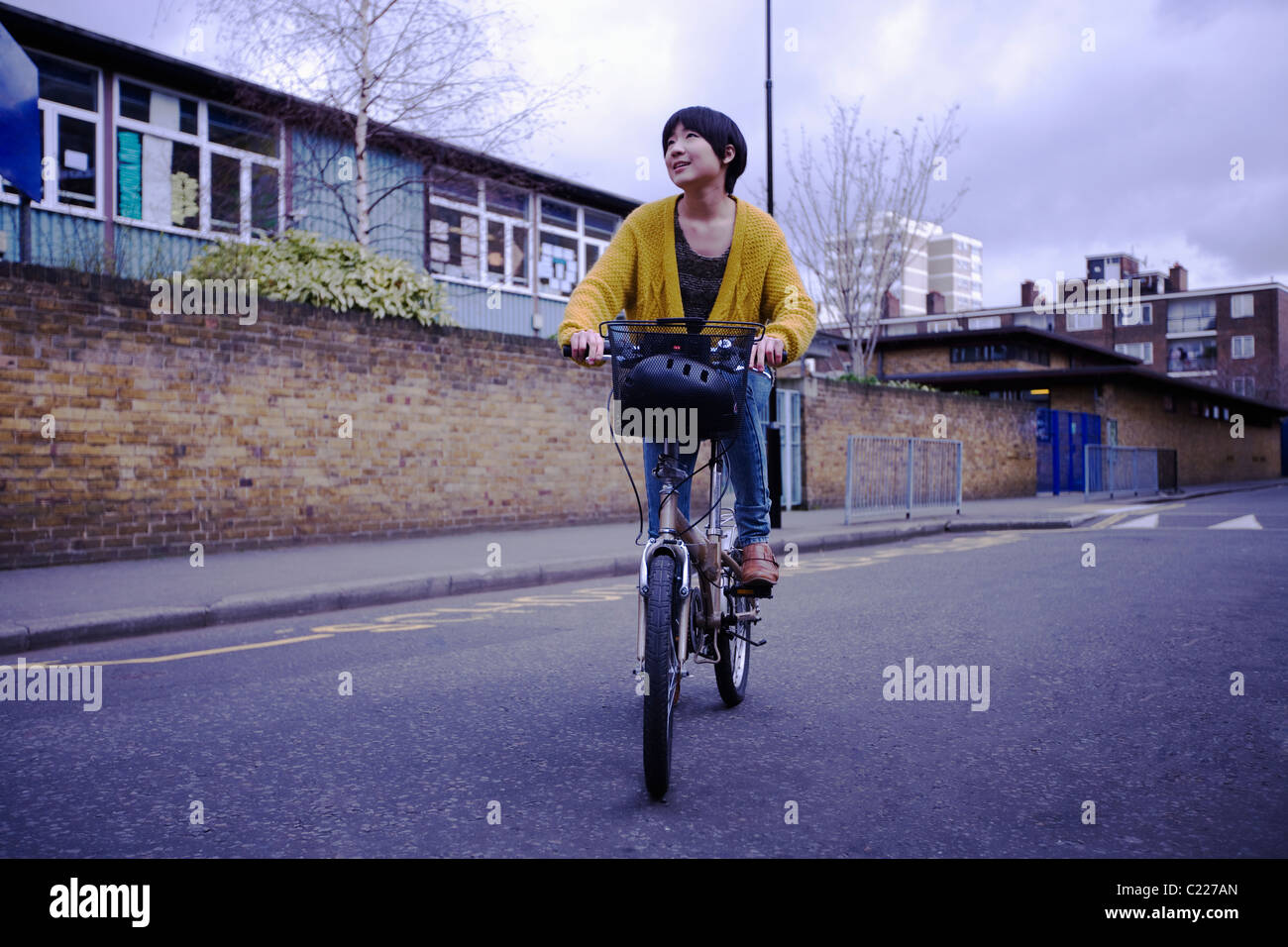 A young female adult riding her bicycle Stock Photo - Alamy