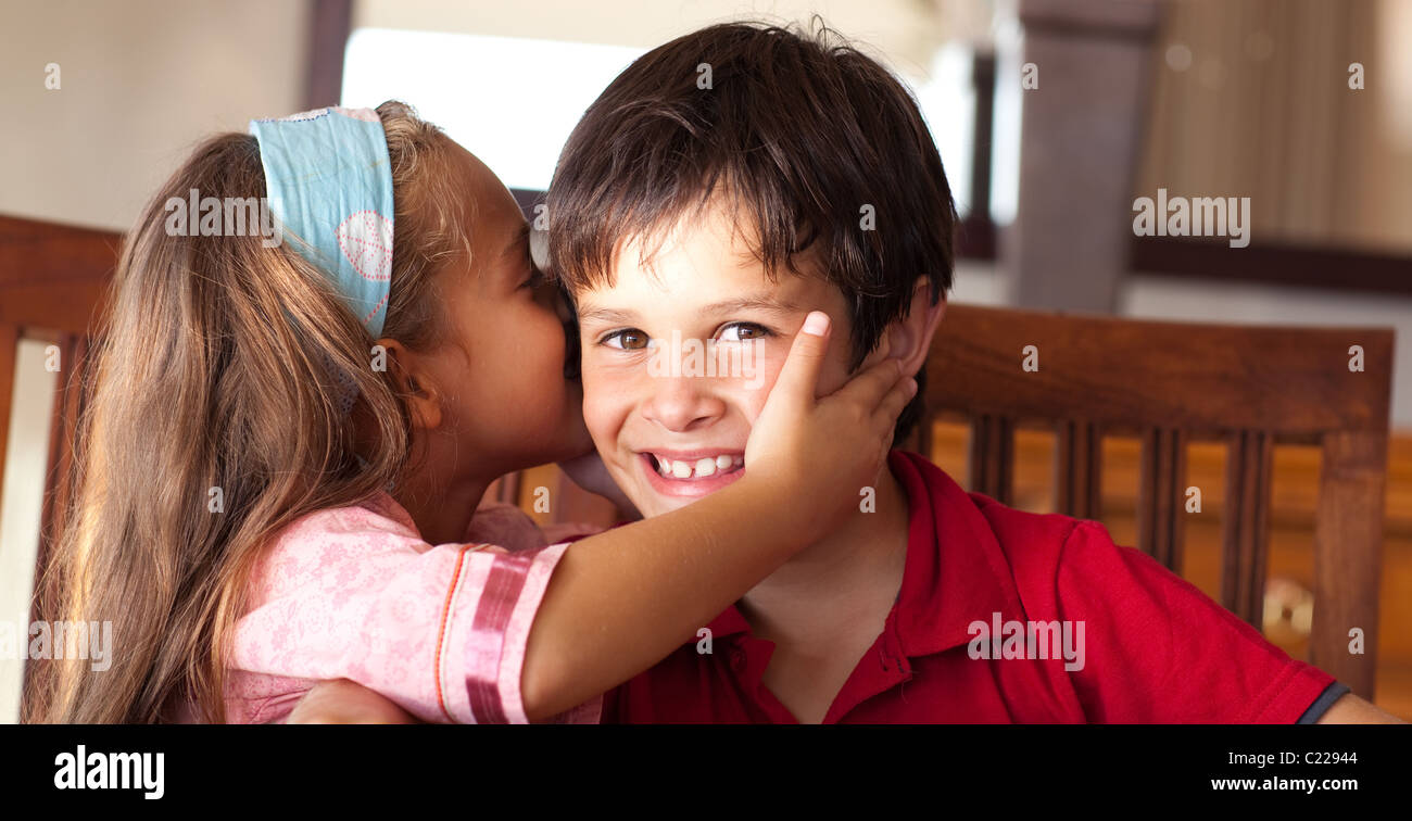 Sweet girl tells her brother a secret Stock Photo - Alamy