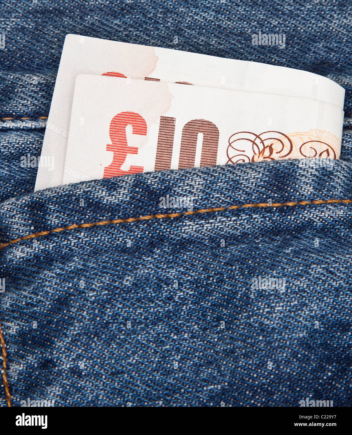 British banknotes £ pound notes sticking out of a blue jeans pocket ...