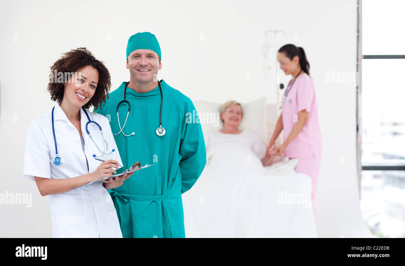 Young medical team standing near a patient Stock Photo - Alamy