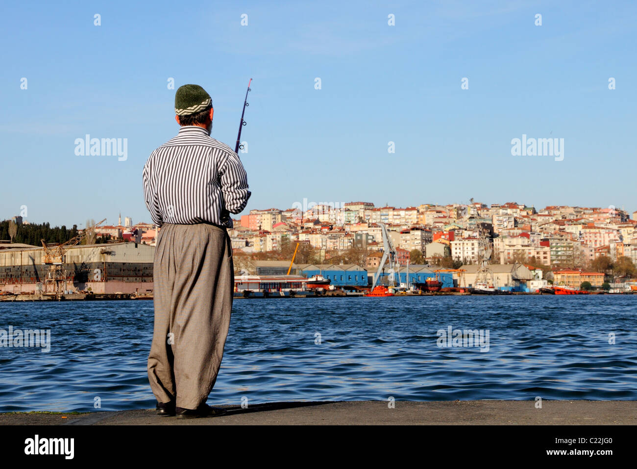 old angler fishing amidst the city of Istanbul in Turkey Stock Photo ...