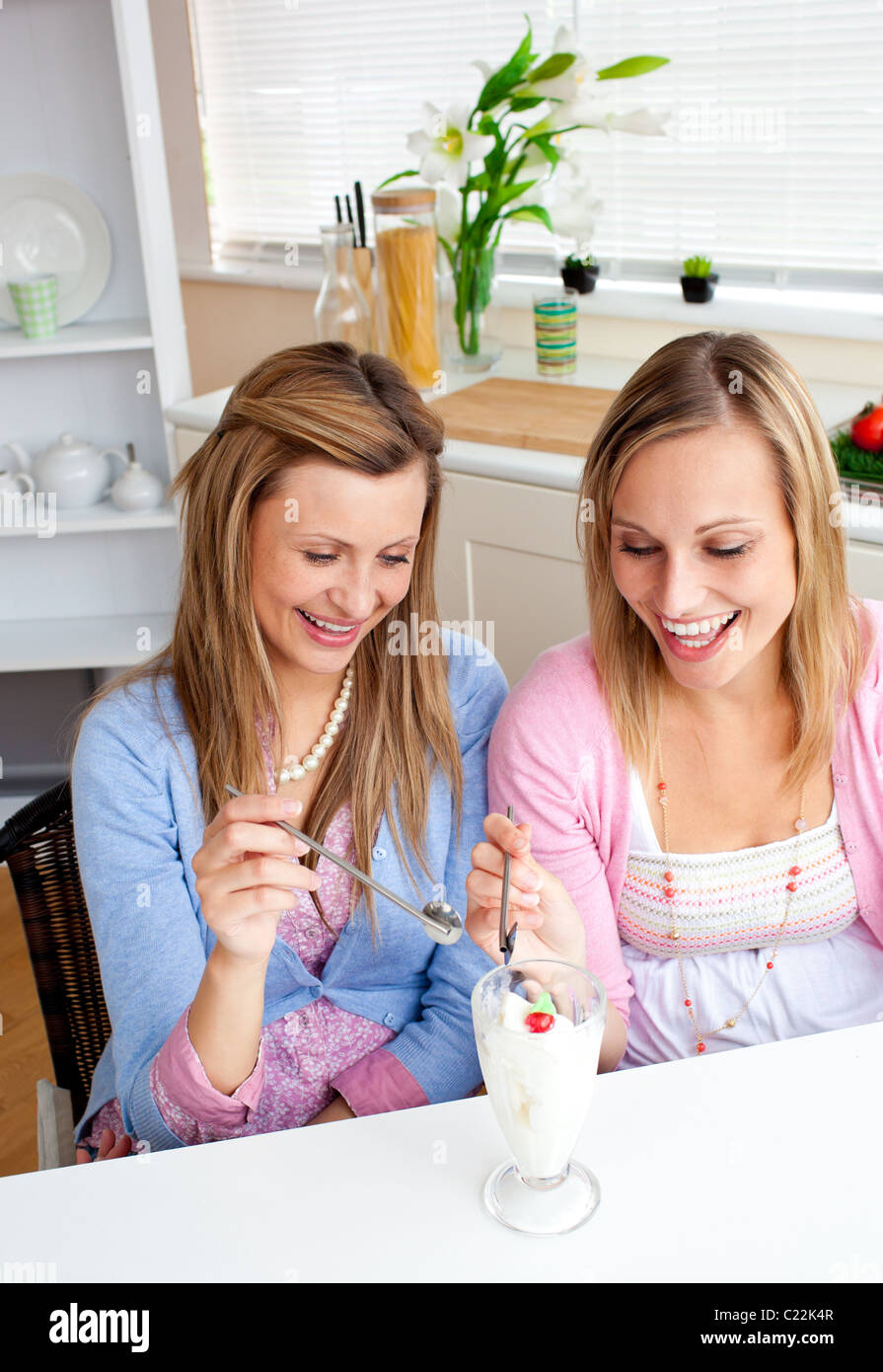 Bright friends eating ice and smiling in the kitchen Stock Photo - Alamy