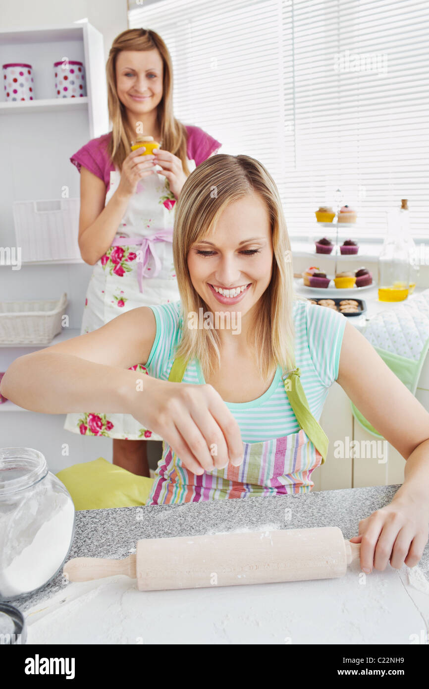 Smiling female friends baking pastry in the kitchen Stock Photo - Alamy