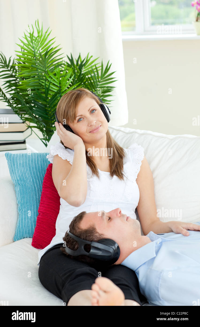 Pretty woman listening to music with her boyfriend Stock Photo - Alamy