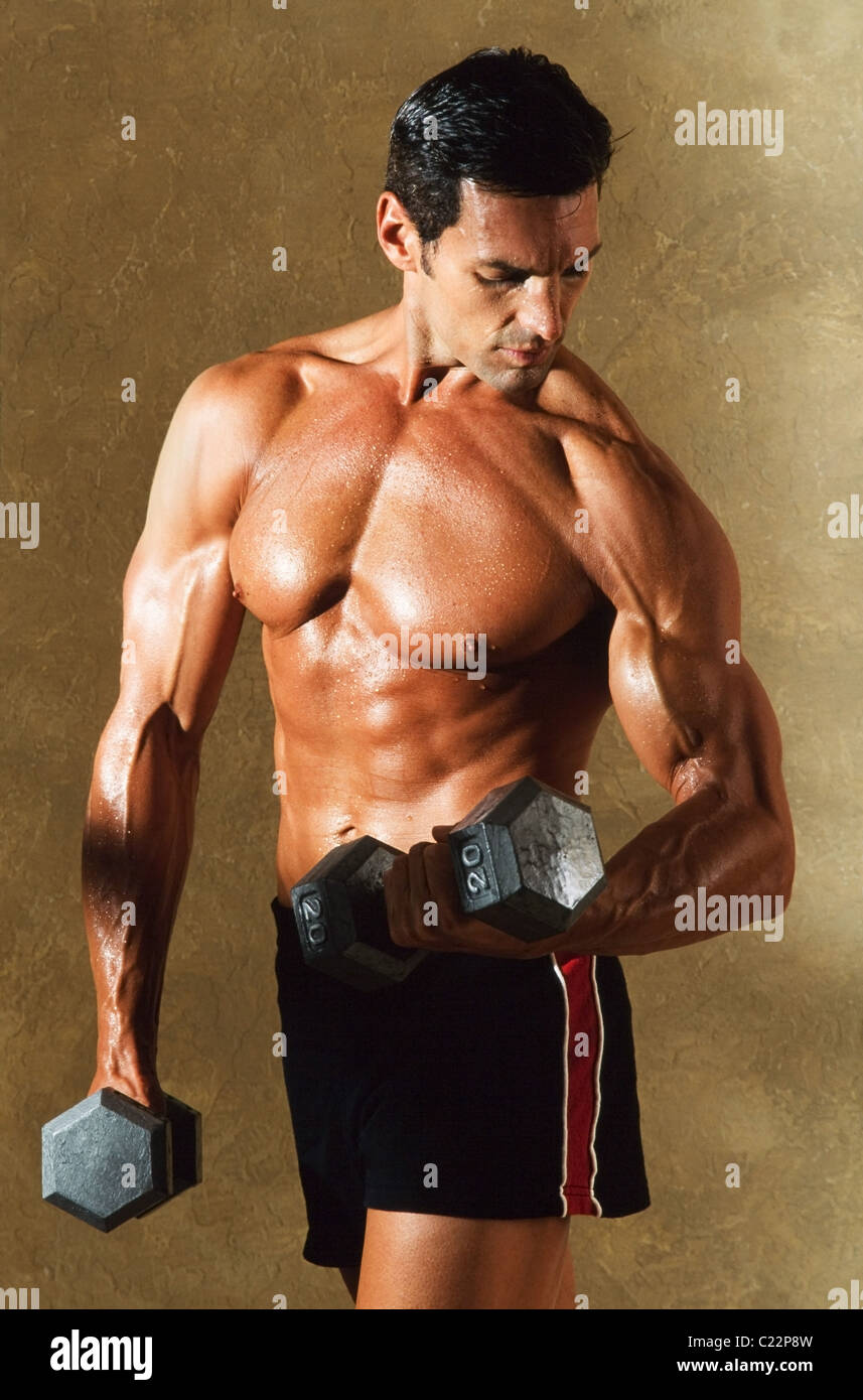 Young man lifting weights,laughing having fun, studio background ...