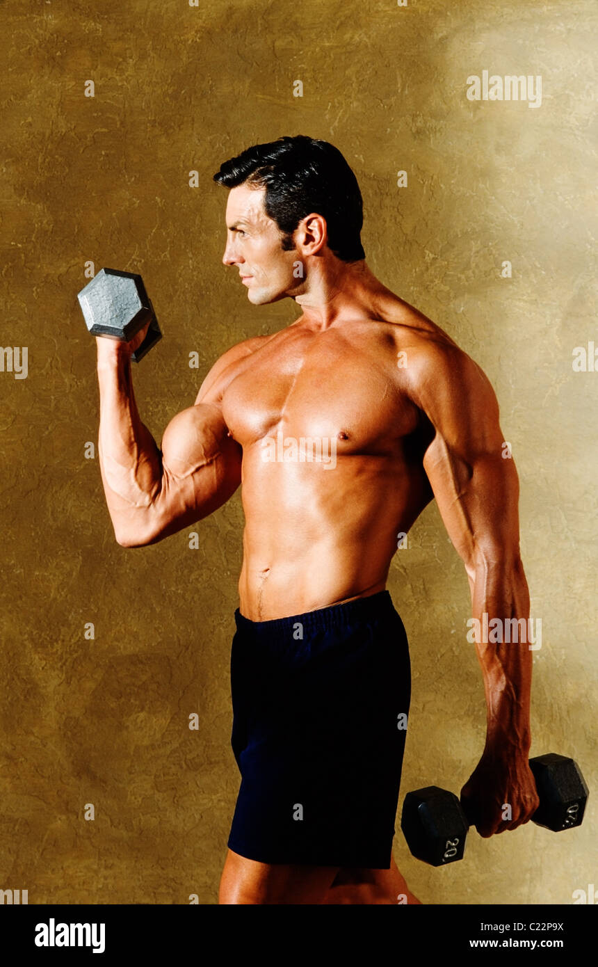 Young man lifting weights,laughing having fun, studio background ...