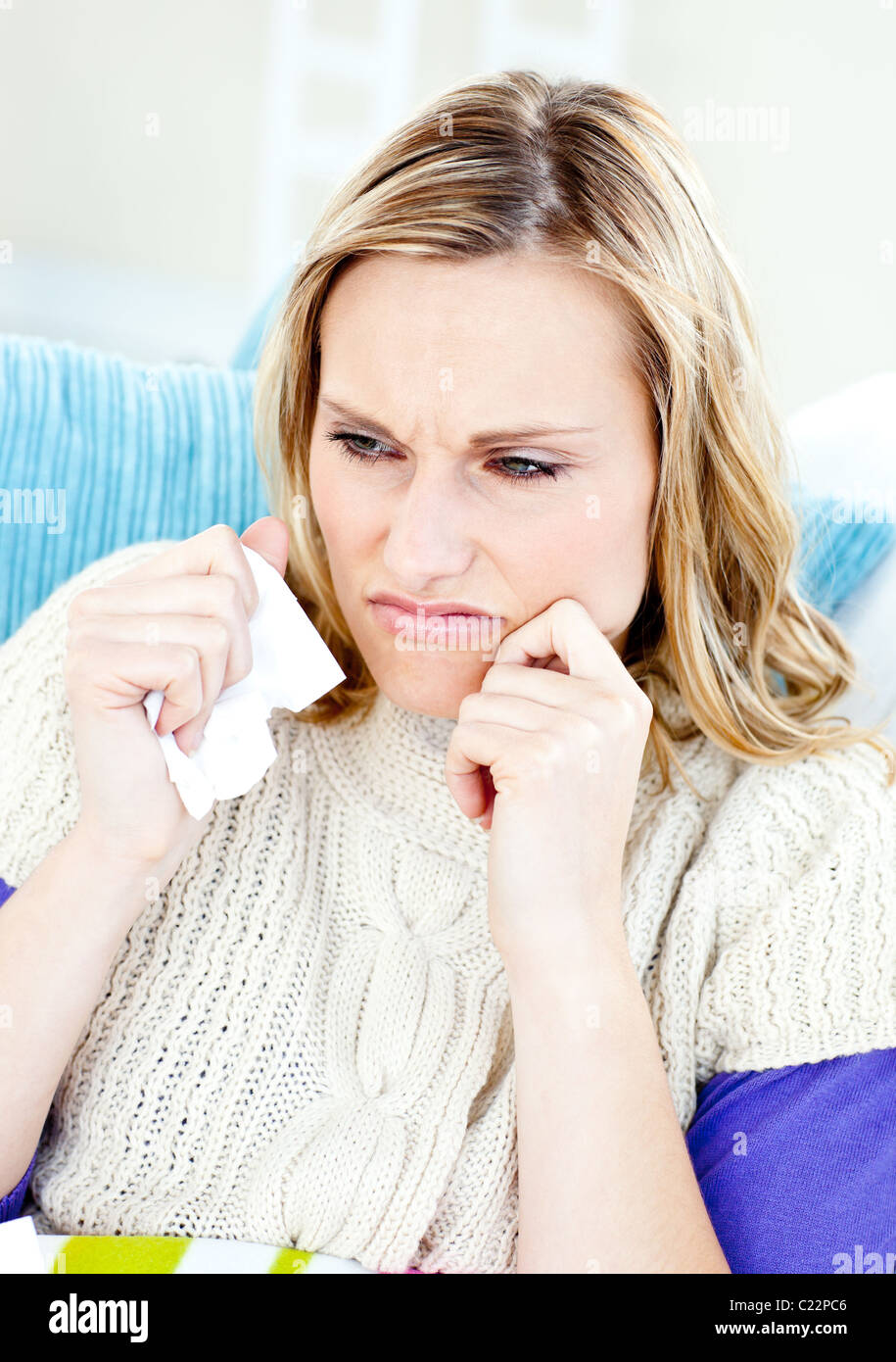 Downcast woman lying on a sofa with tissues Stock Photo - Alamy