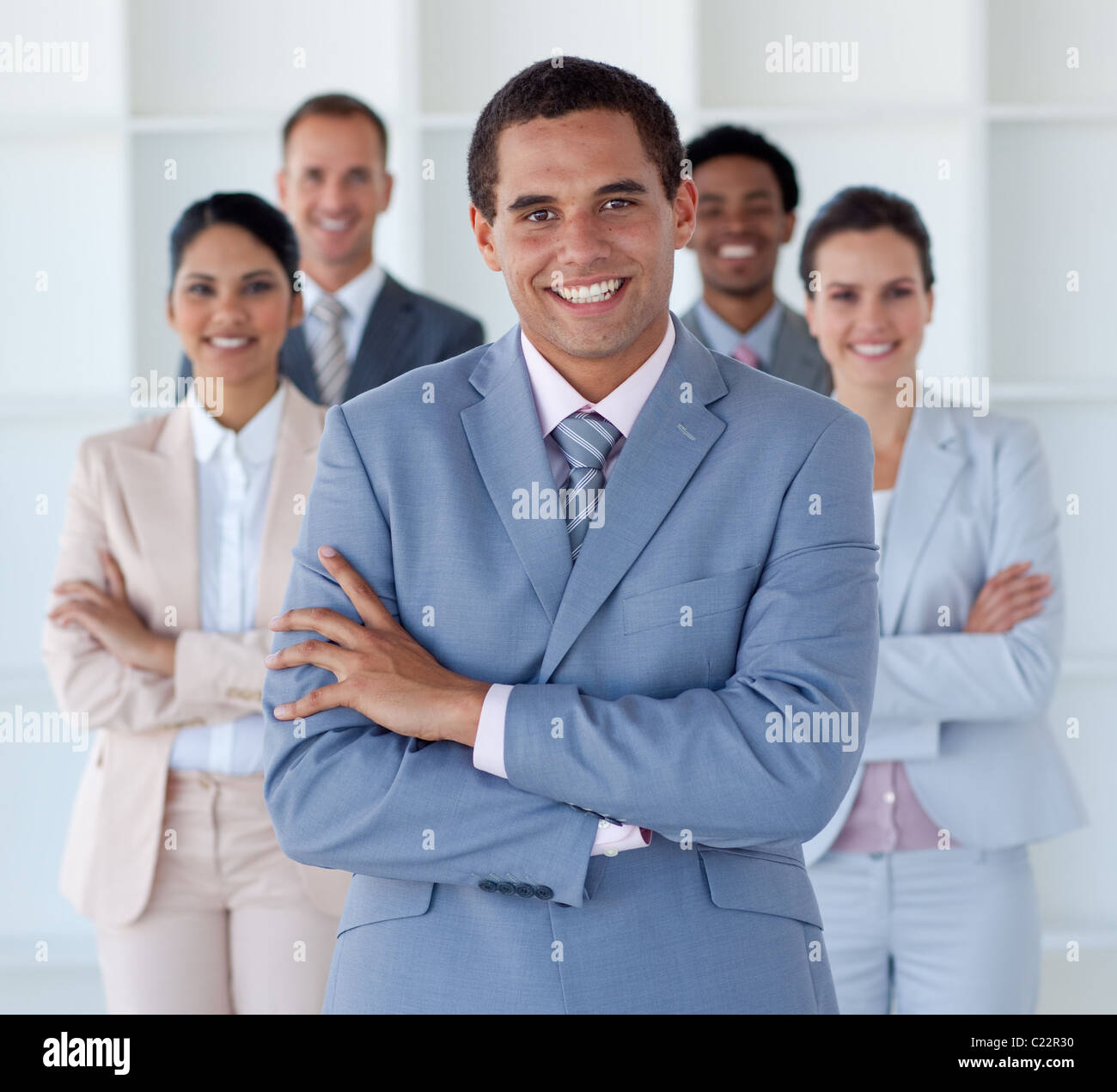 Smiling businessman leading his team Stock Photo - Alamy