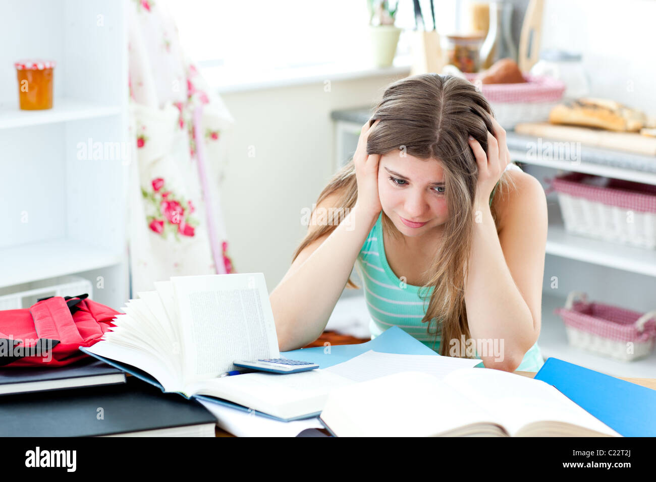 Tired student doing homework sitting in the kitchen Stock Photo - Alamy