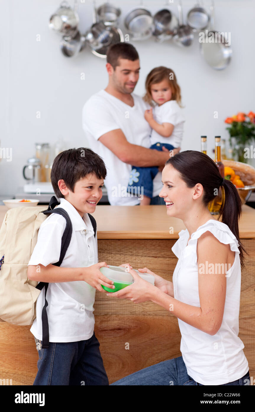 Smiling mother giving school lunch to her son Stock Photo - Alamy