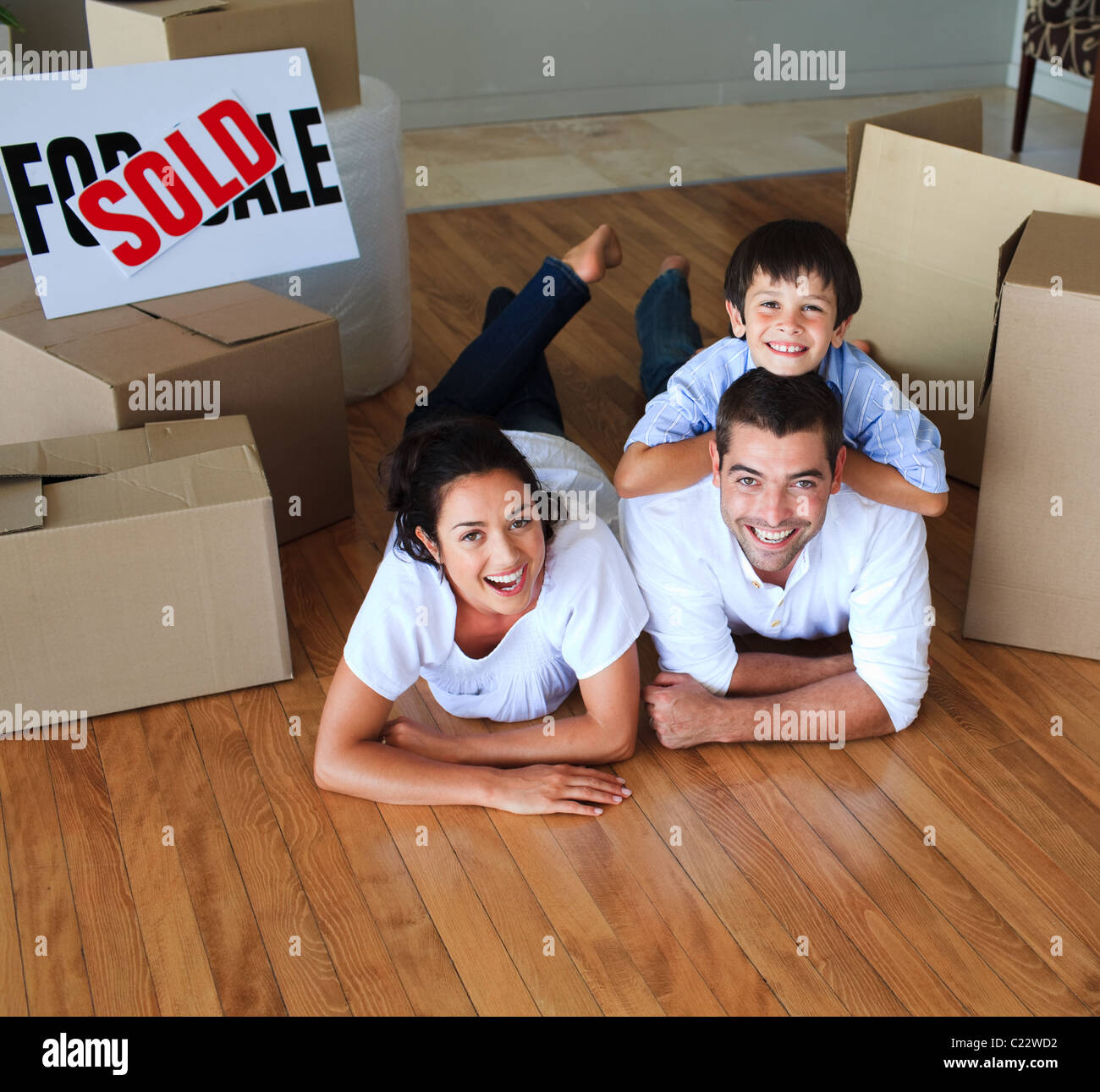 Family moving house on floor smiling at the camera Stock Photo - Alamy