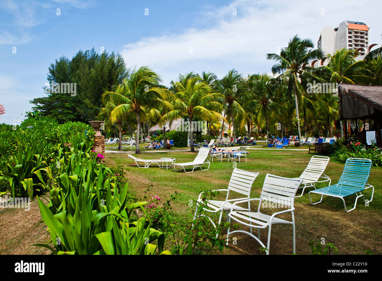 Holiday makers relax in a beach front resort at Batu Feringgi Stock ...