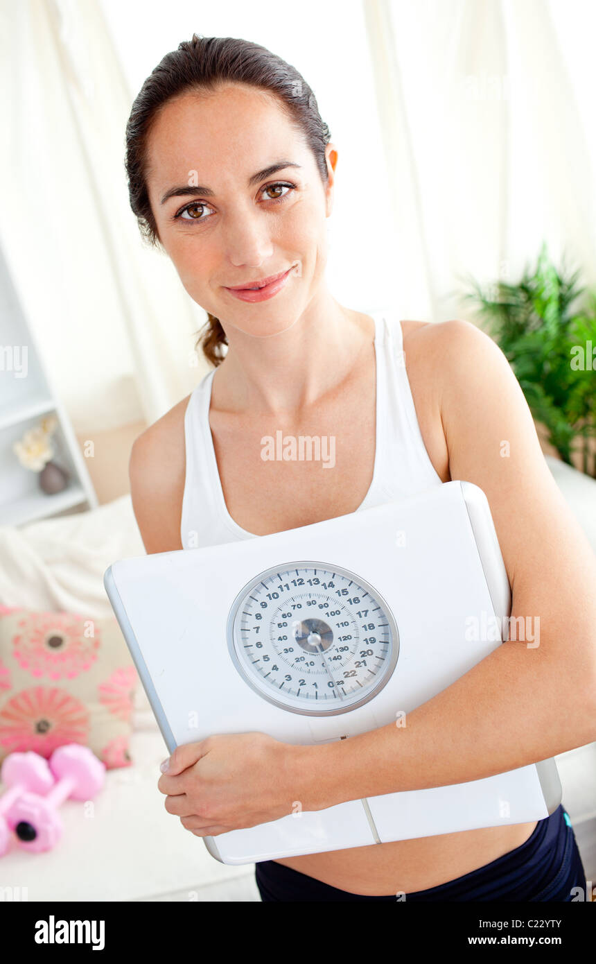 Portrait of a beautiful woman holding a scale in her living-room Stock ...