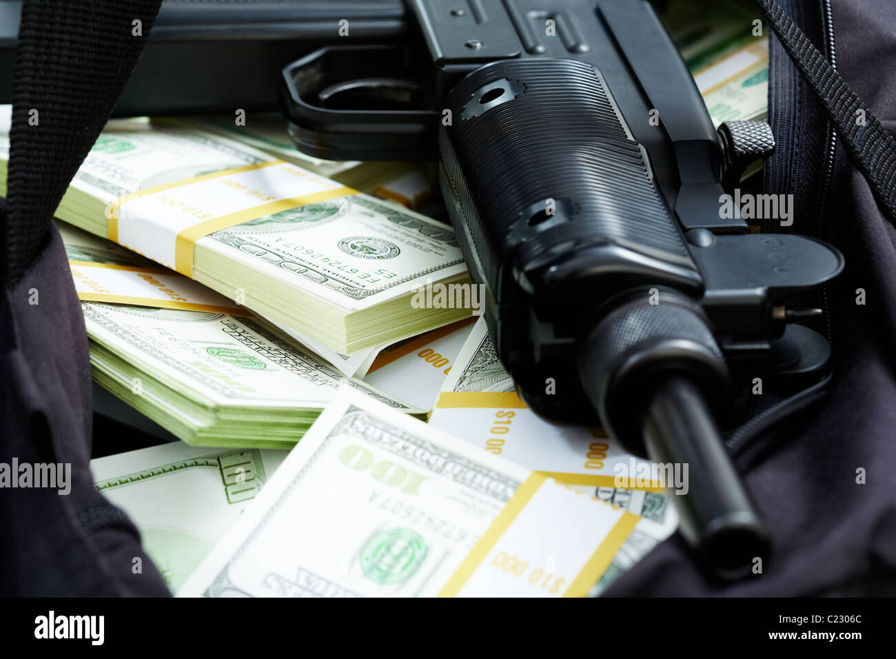 Close-up of black weapon lying on heap of hundred dollar bills Stock ...
