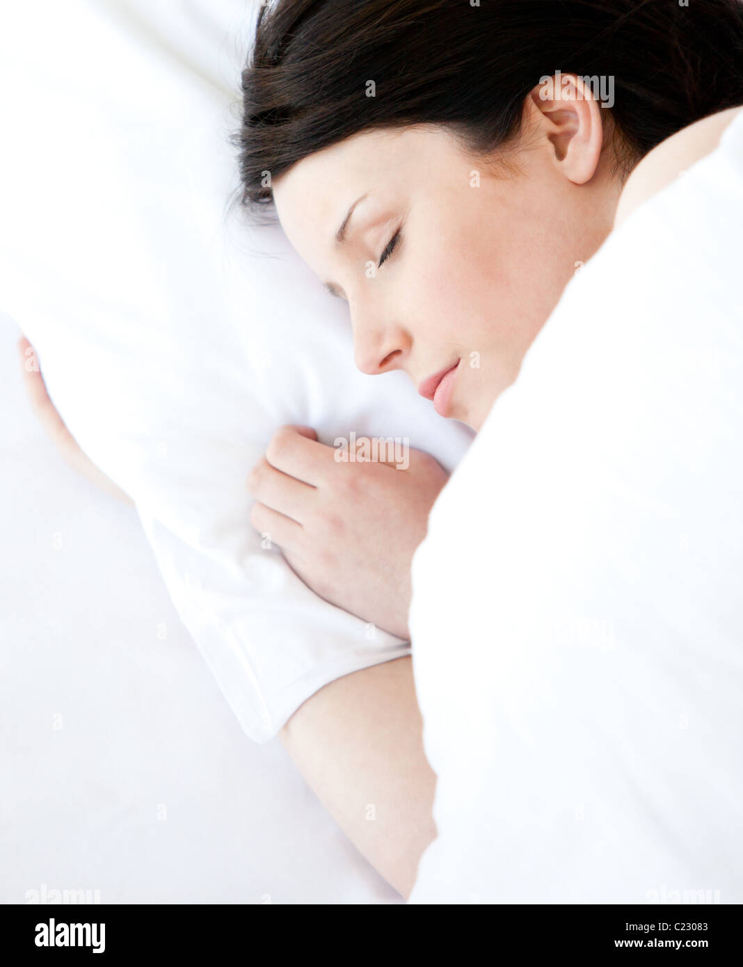 Pretty young woman lying in a bed sleeping Stock Photo - Alamy