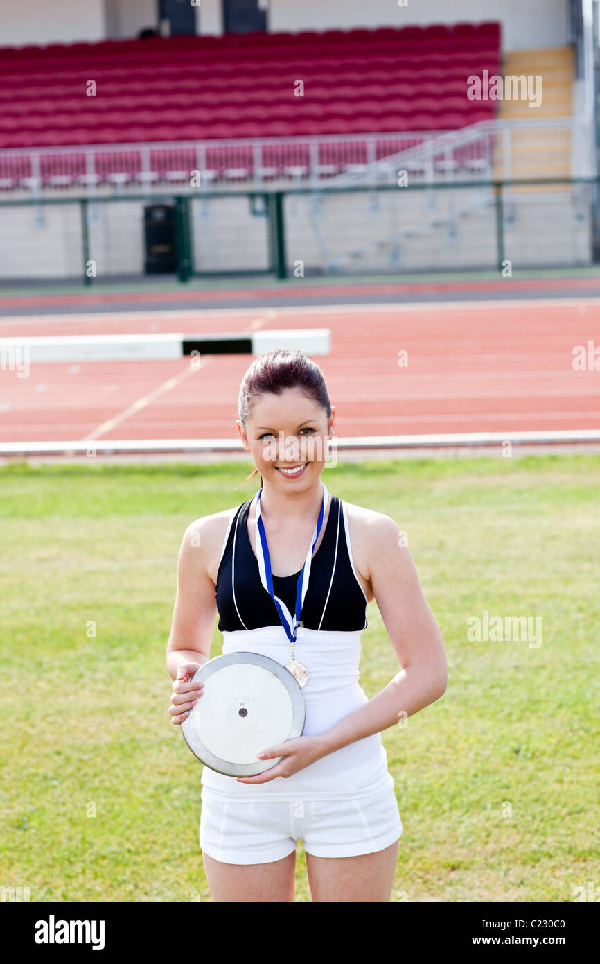 Smiling female athlete with a gold medal holding a disc Stock Photo - Alamy