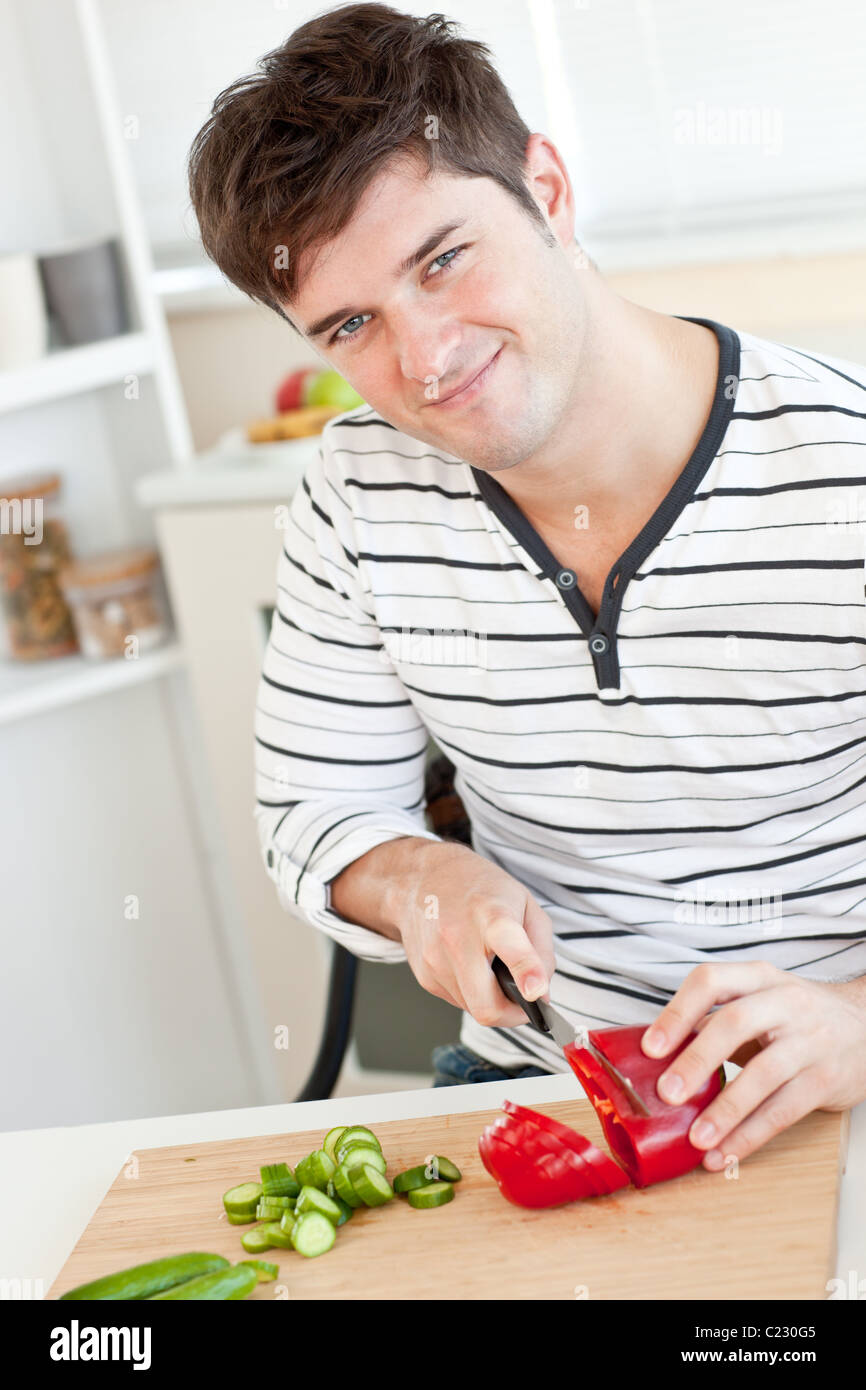 Smiling young man cutting vegetables in the kitchen Stock Photo - Alamy