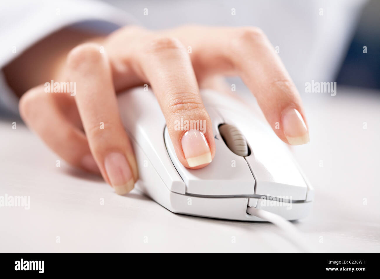Close-up of female hand on white mouse Stock Photo - Alamy