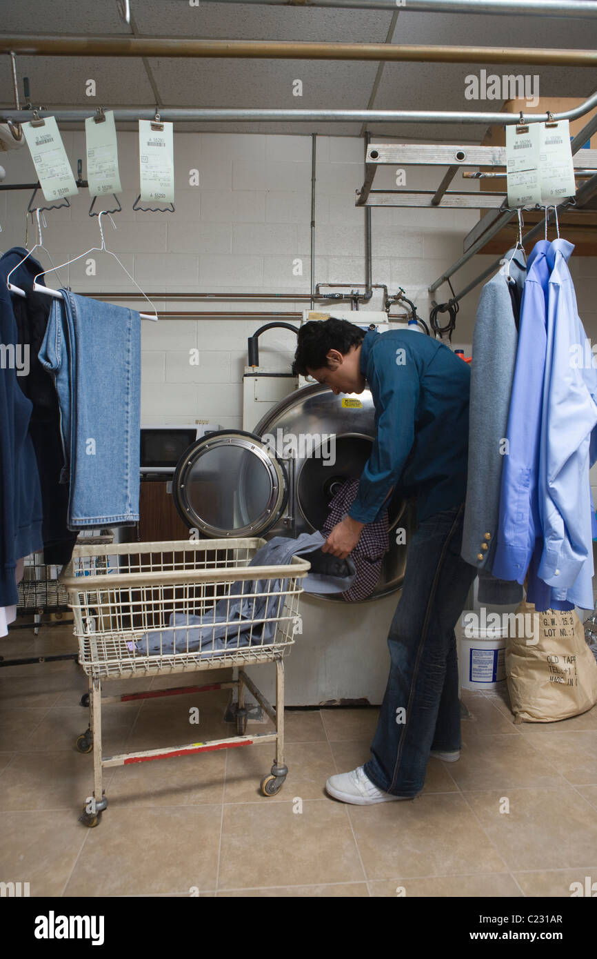 Man loading clothes into the washing machine Stock Photo - Alamy