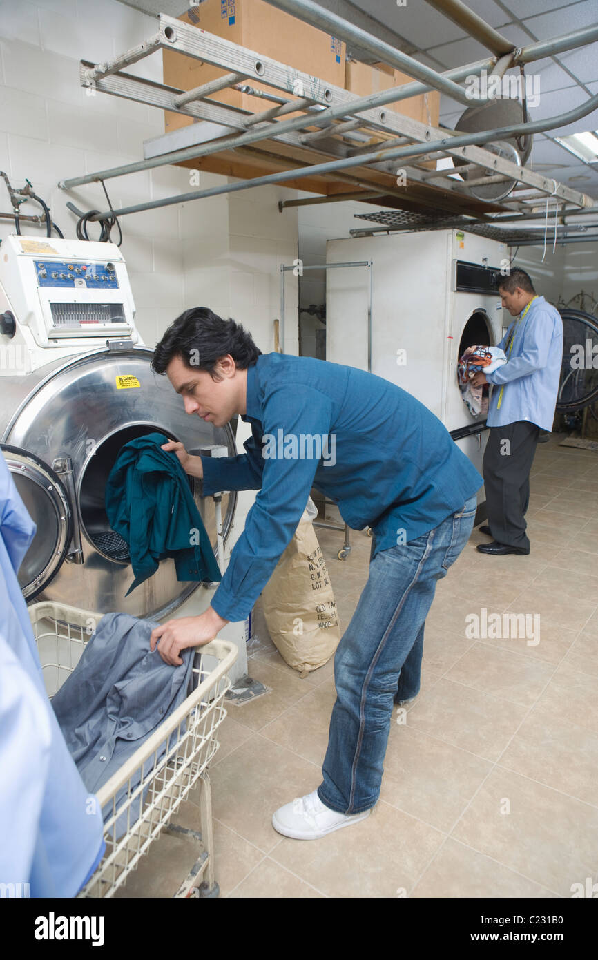 Man loading clothes into the washing machine Stock Photo - Alamy