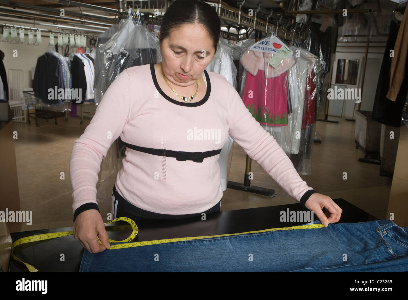Mature woman measuring in the laundrette Stock Photo - Alamy