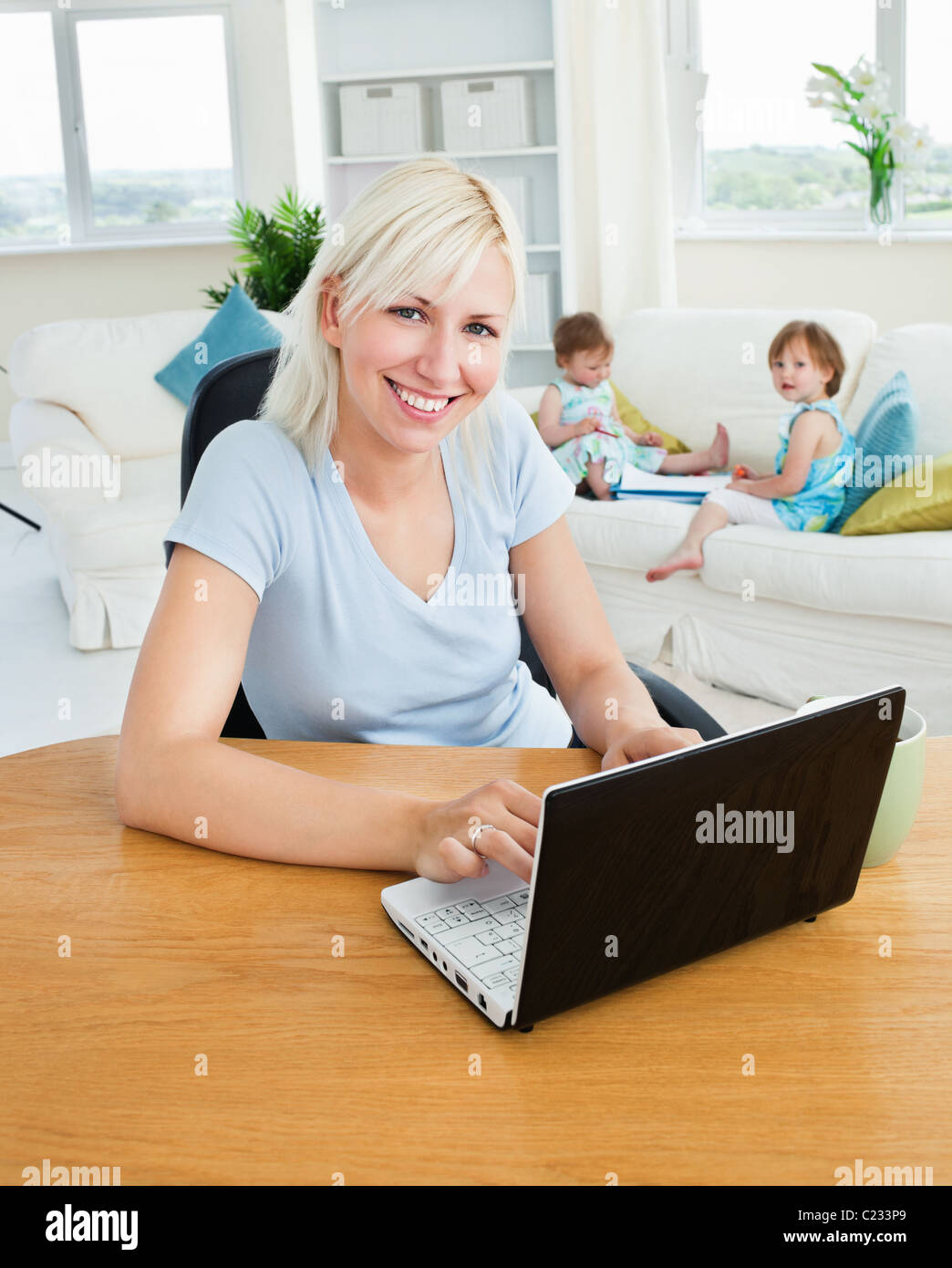 Blond mother using laptop Stock Photo - Alamy