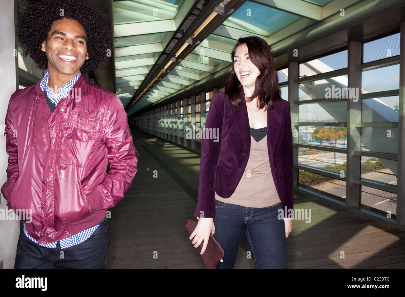 Two young people walking and joking in an urban setting - sharp focus ...